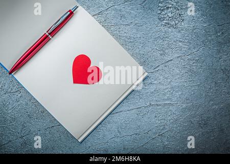 Red heart biro pen notepad on metallic background education concept ...