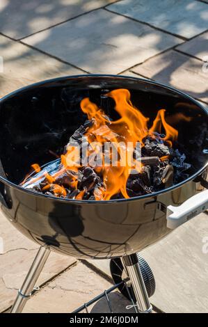 round BBQ with lit charcoal wood with flames Stock Photo - Alamy