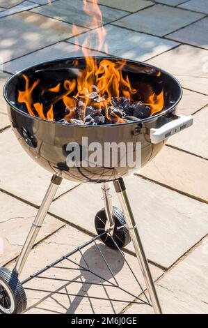 round BBQ with lit charcoal wood with flames Stock Photo - Alamy