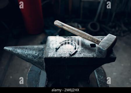 Blacksmith's hammer on metal anvil at forge. Overhead view Stock Photo ...