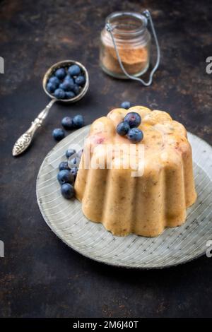 Traditional English plum pudding as closeup with fruits on a dessert ...