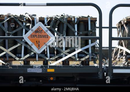 Pallets holding munitions are transported off an aircraft cargo loader ...