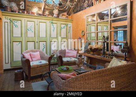 Wicker armchairs, love seat and wooden coffee table in living room ...