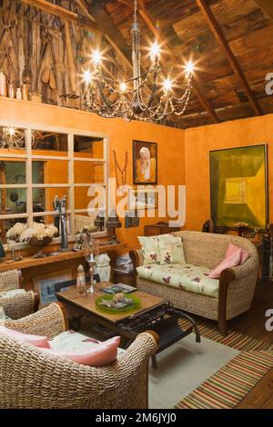 Wicker armchairs, love seat and wooden coffee table in living room ...