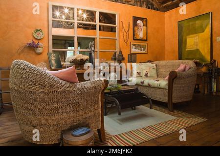 Wicker armchairs, love seat and wooden coffee table in living room ...