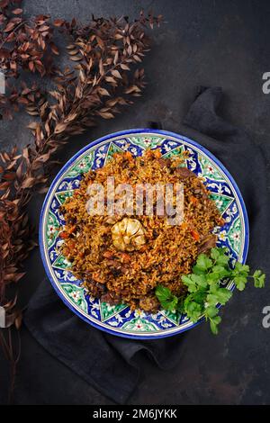 Traditional Uzbek fergana plov with devsira rice and lamb meat served ...