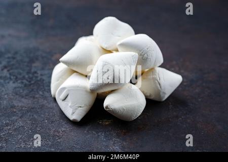 Traditional Afghan dried curd kashk pieces as close-up on black rustic ...