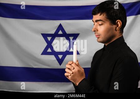 Jewish man with candle against flag of Israel. Honoring victims of ...