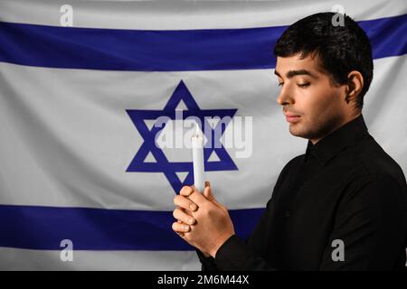 Jewish man with candle against flag of Israel. Honoring victims of ...
