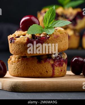 Portion crumble pie with cherries on a wooden board decorated with ...