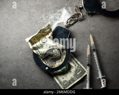 Handcuffs, dollar bills and drug powder Stock Photo - Alamy
