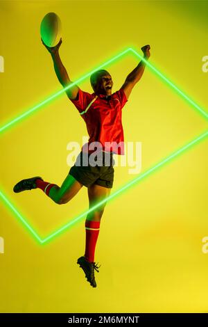 African american rugby player with arms raised throwing ball over ...