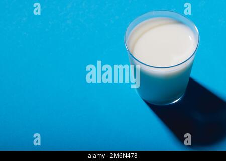 High angle view of glass of milk on blue background, copy space Stock ...