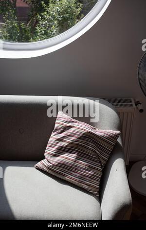 Interior of living room with grey sofa, table, pouf and stepladder near ...