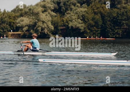Sportsman single scull man rower rowing on boat Stock Photo - Alamy