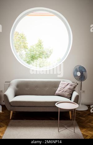 A grey modern cozy armchair in a living room Stock Photo - Alamy
