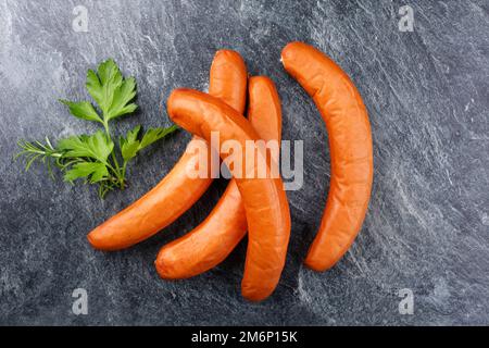 Traditional raw German bockwurst offered as top view on rustic black ...