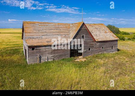 An aerial shot of an old wooden barn with a field in the background in ...