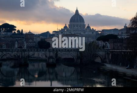 The sun sets behind St. Peter's Basilica at the Vatican, Friday, Feb ...