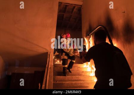 Brave Fireman Descends Stairs of a Burning Building and Holds Saved ...