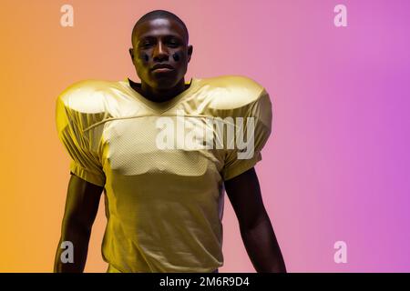 African american male american football player holding ball with neon ...