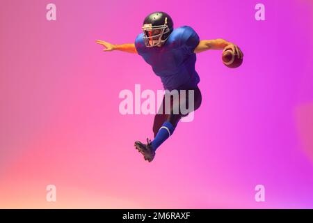 Caucasian male american football player holding ball with neon yellow ...