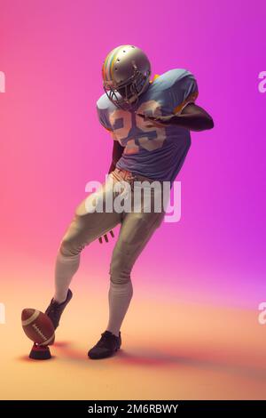 African american male american football player holding ball with neon ...