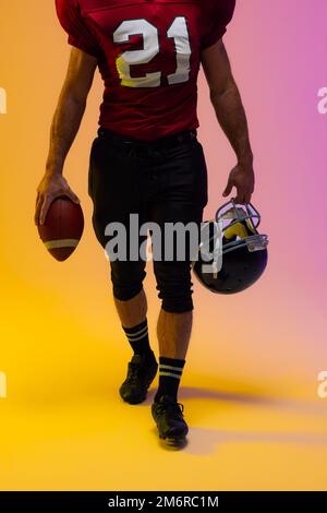 Midsection of caucasian male american football player with neon purple ...