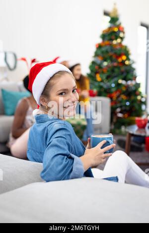 Image of diverse friends celebrating christmas and making laptop video ...