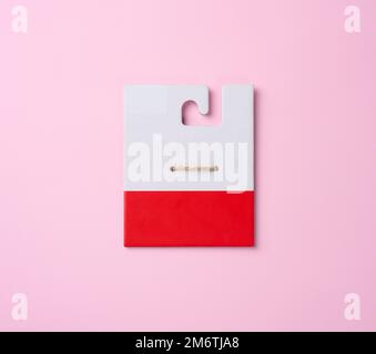 Empty white cardboard tag on a white rope, red background with hearts ...