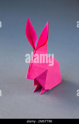 Pink paper rabbit origami isolated on a blank grey background Stock ...