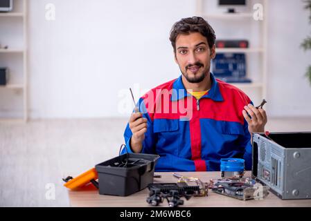 Young male repairman repairing computer PC Stock Photo - Alamy