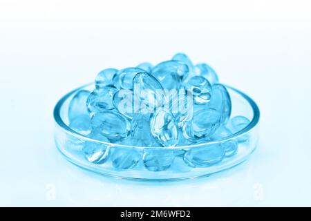 Soft gelatin capsules of essential oil in the glass dish isolated on ...