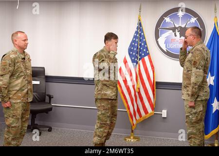 Air Force Col. Robert Lyons (left), receives a framed copy of his ...