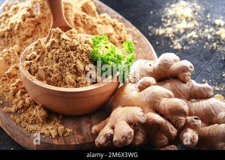 A bowl with ground ginger and its fresh rhizome Stock Photo - Alamy