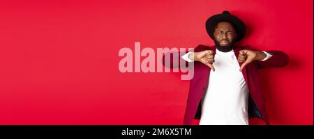 Disappointed Black man leave negative feedback, showing thumb down and ...