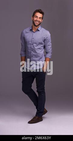 Rugged and manly. Studio shot of a handsome man against a gray ...