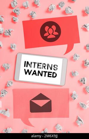 Hand writing sign Interns Wanted. Concept meaning Looking for on the ...