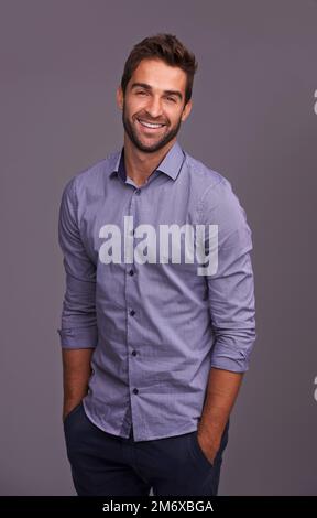 Rugged and manly. Studio shot of a handsome man against a gray ...