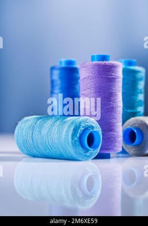 Five spools of blue sewing thread on gray stone floor Stock Photo - Alamy