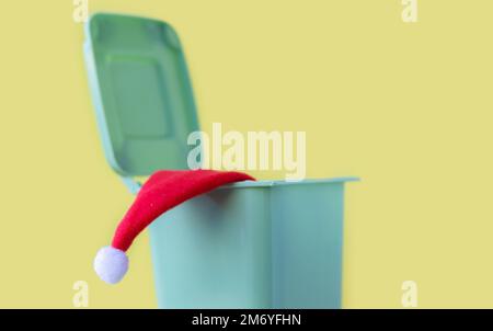 red color small lsanta cap hat throw away dropped off in mini trash bin ...