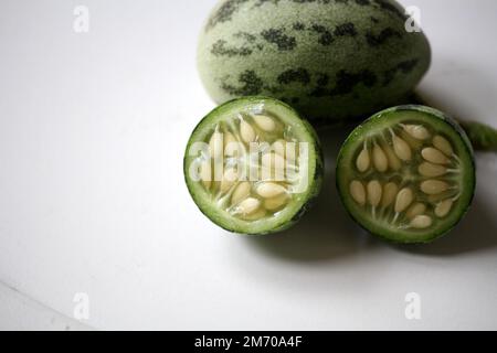 Prickly paddy melon (Cucumis myriocarpus) a small green fruit with dark ...
