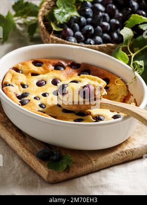 red grape clafoutis, French cuisine. on a table made of ceramic tiles ...
