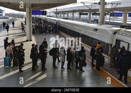 Passengers line up to enter the bullet train at the high speed rail ...