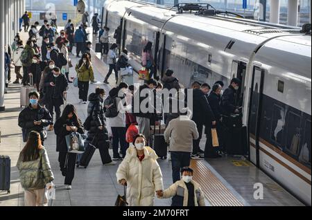 Passengers line up to enter the bullet train at the high speed rail ...