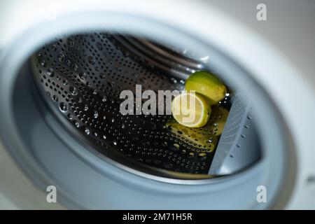 lemon inside washing machine. Half a lemon is placed on top of a whole ...