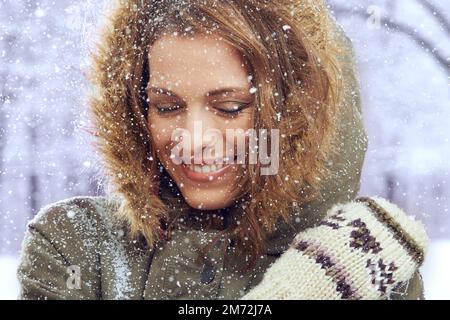 Loving the first snowfall. an attractive woman enjoying herself outside ...