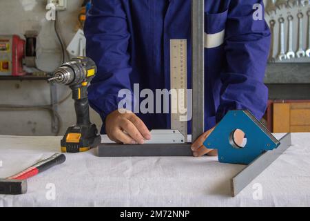 metalworker in the workshop who finds the precise angle of a mechanical ...