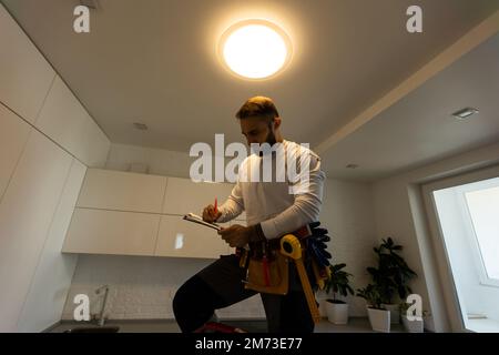 Installation lighting. Builder is holding a tablet in his hands ...