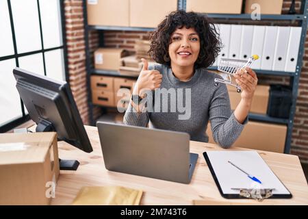 Young brunette woman standing by manikin at small business holding i am ...